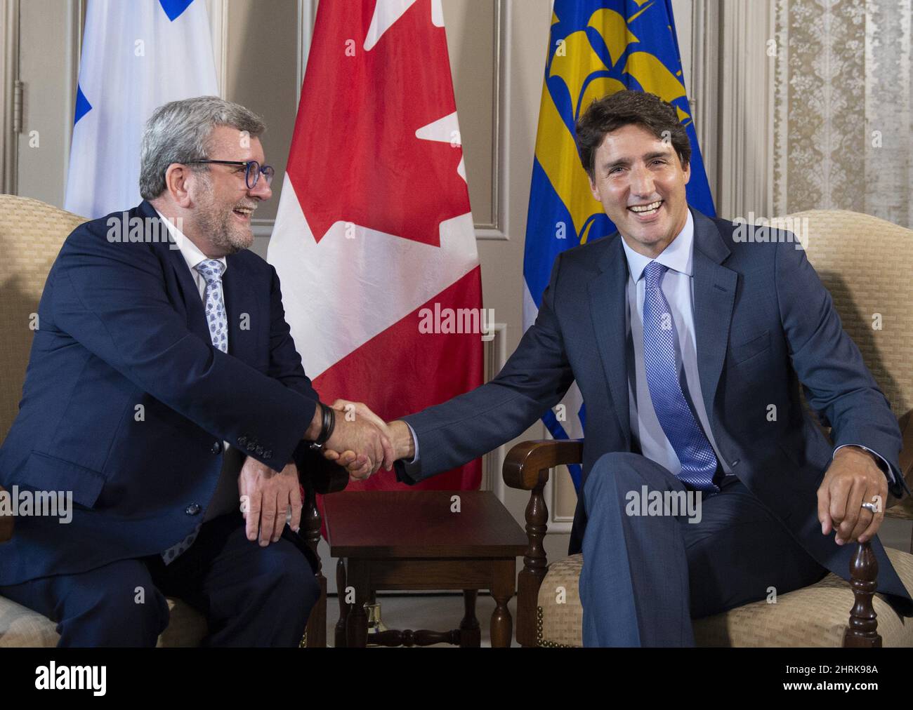 Prime Minister Justin Trudeau, right, shakes hands with Quebec City ...