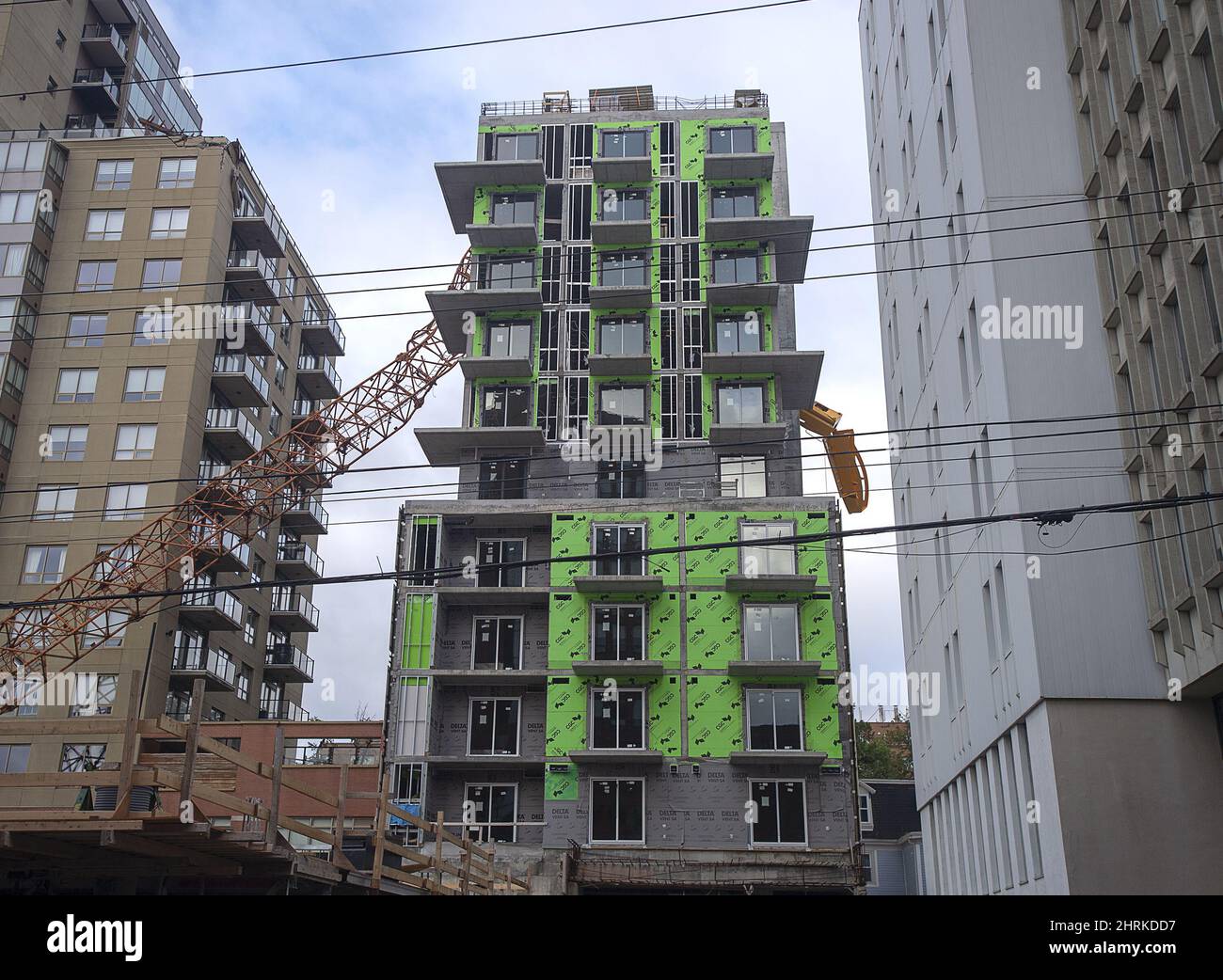A toppled building crane is draped over a new construction project in ...