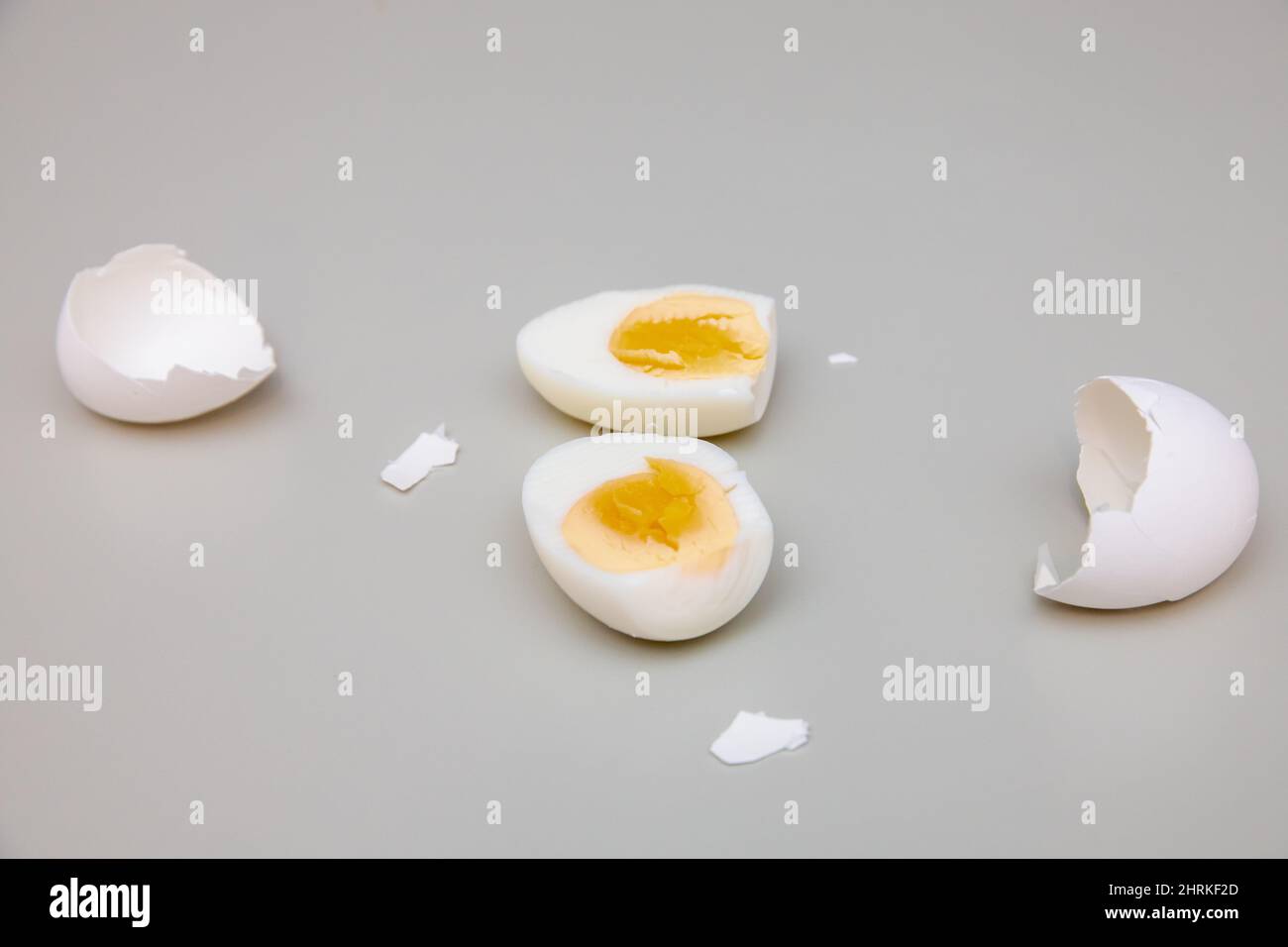 Boiled egg cut in half surrounded by its shell parts Stock Photo - Alamy