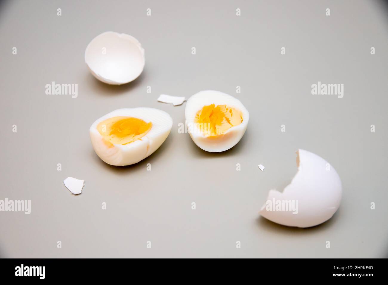 Boiled egg cut in half surrounded by its shell parts Stock Photo - Alamy