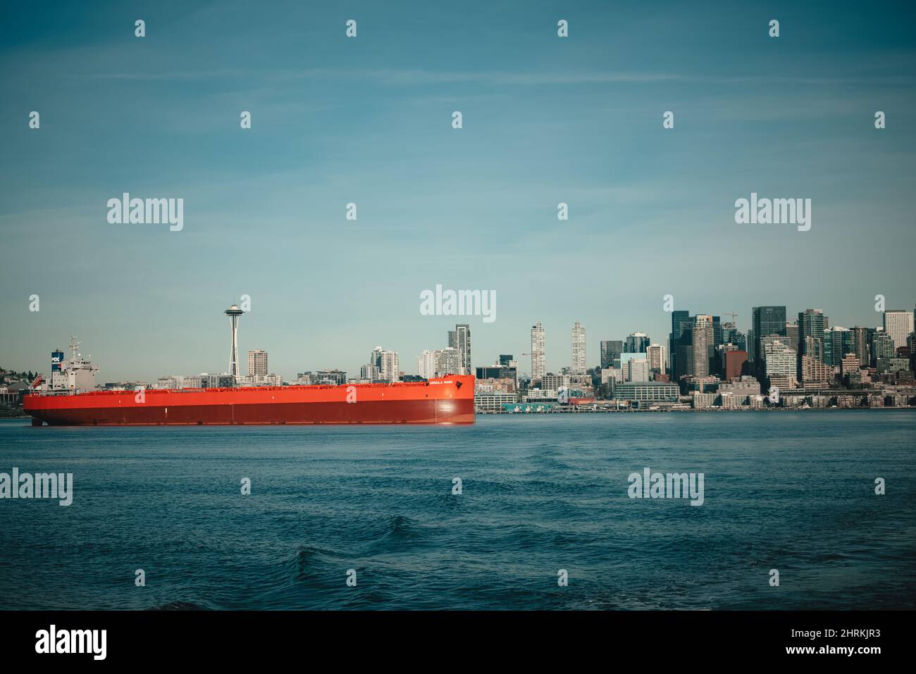 Blue sky over the river with a large ship and modern skyscrapers on a ...