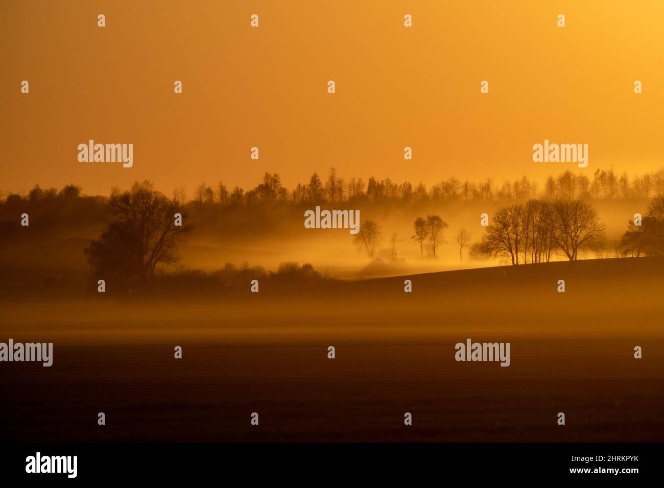 Hazy landscape field during sunset Stock Photo - Alamy