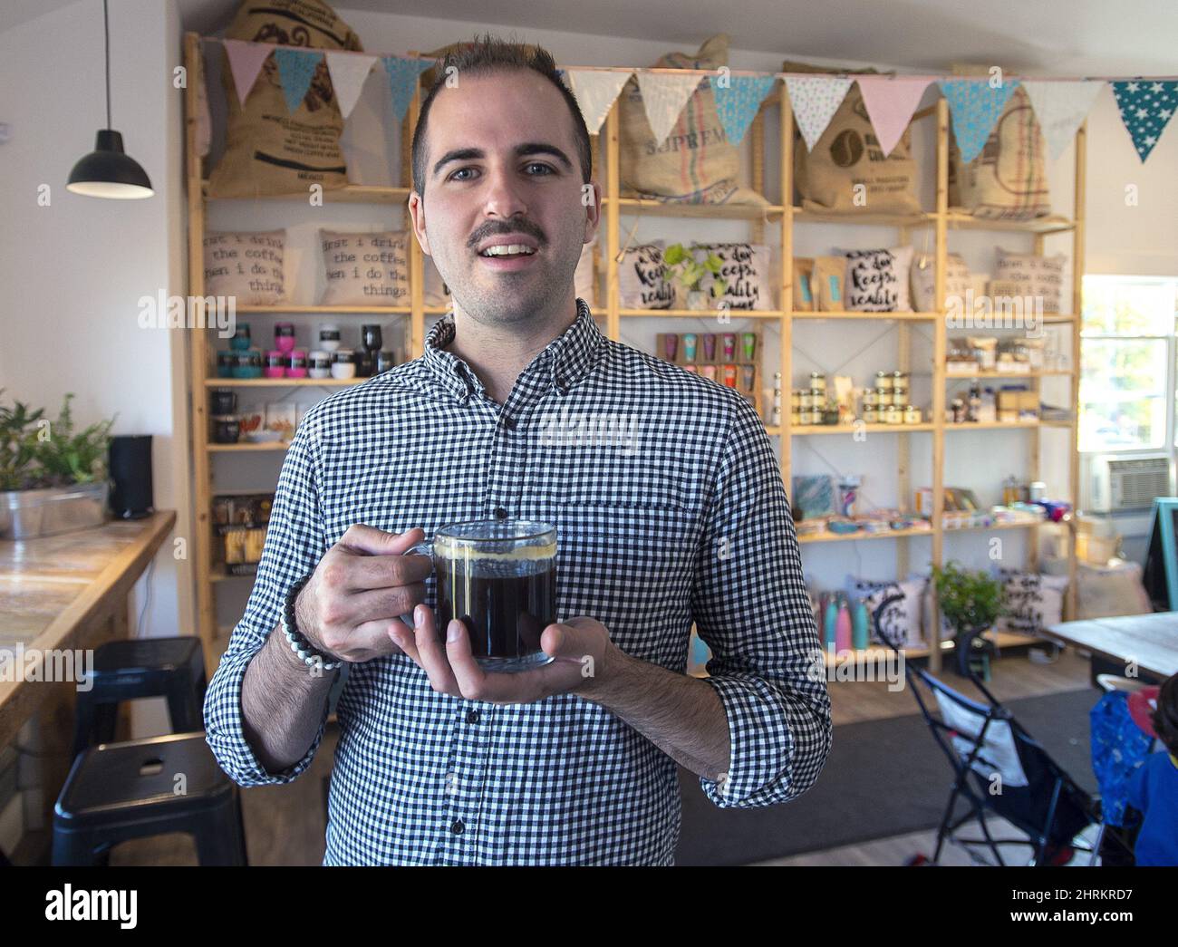 Jason Selby takes a break in his cafe in Dartmouth, N.S., on October 16 ...