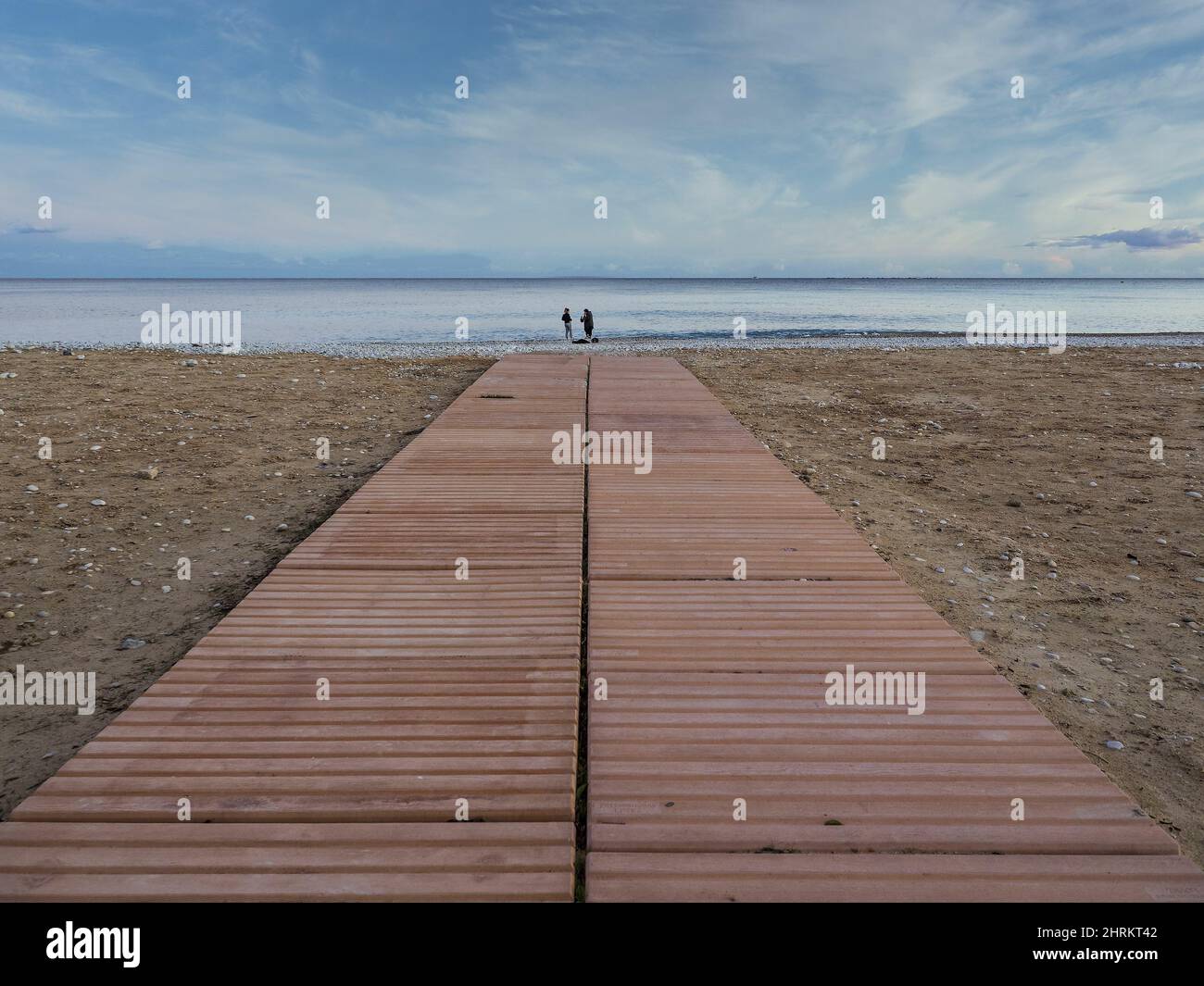 Landscape of a wooden walkway on the beach surrounded by the sea under ...