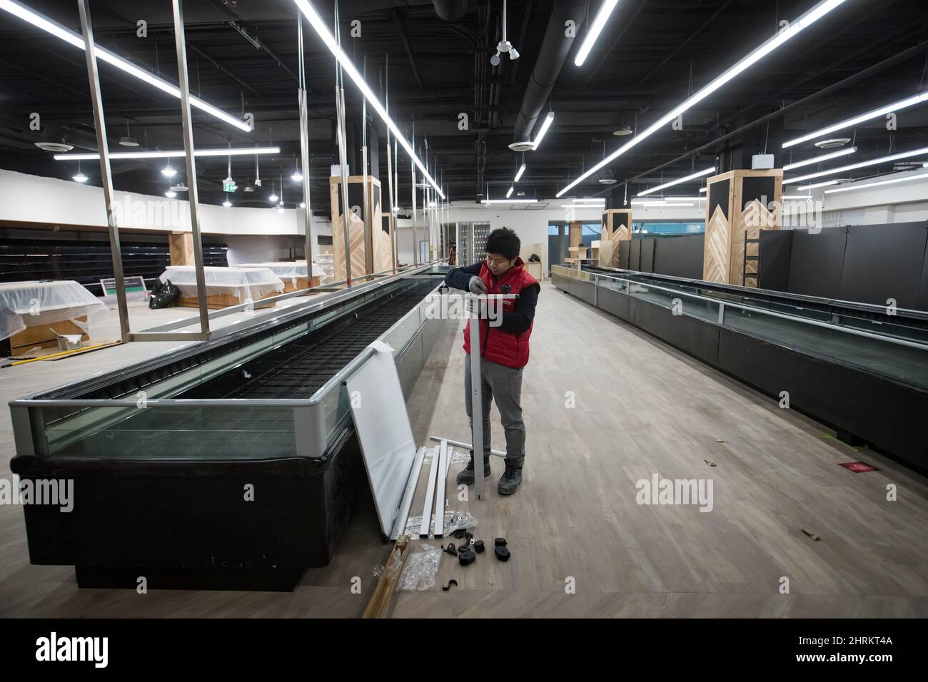 A worker assembles a fixture at a Sungiven Foods grocery store under ...