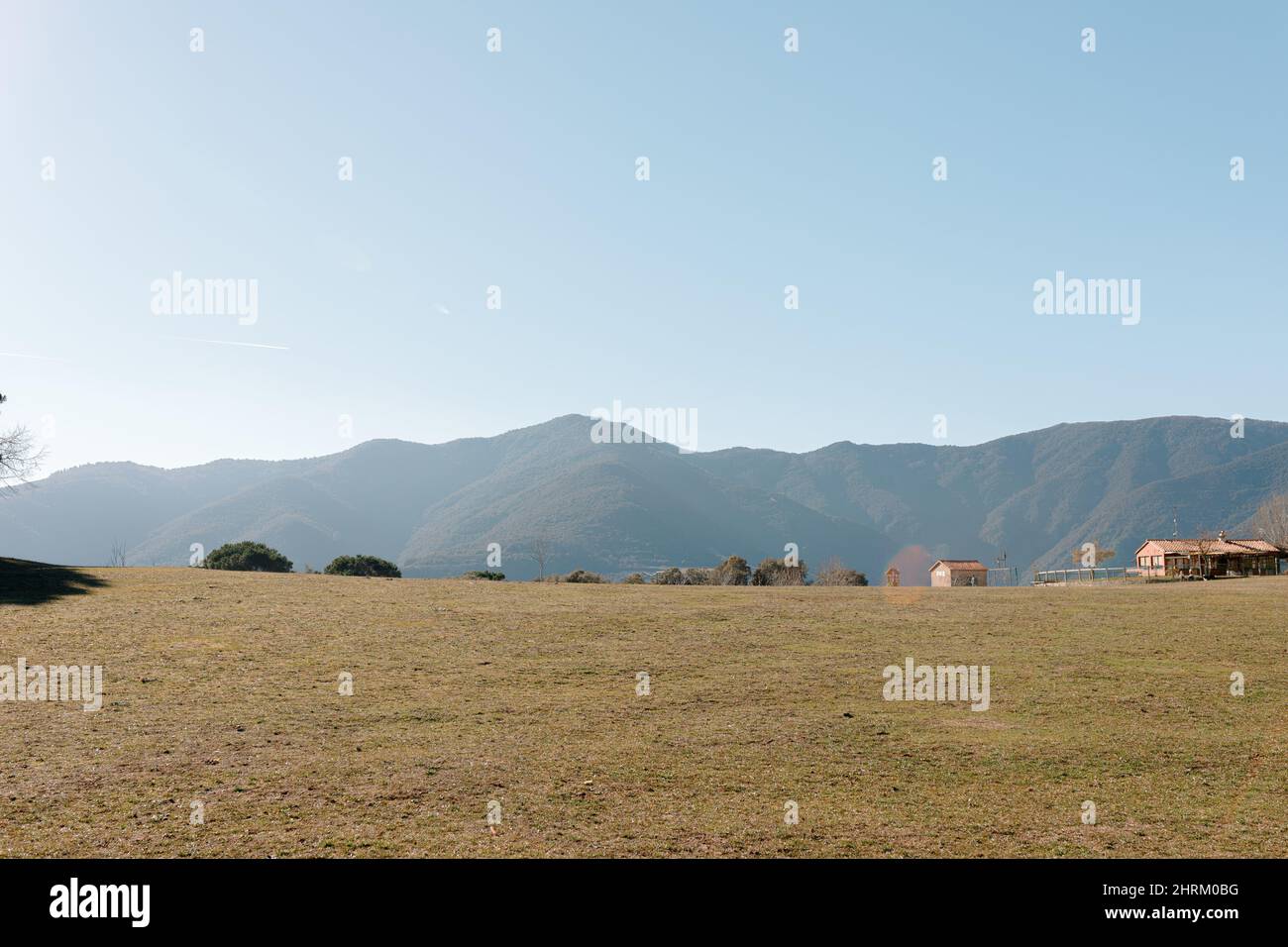 Landscape of houses on an open field with mountains background Stock ...