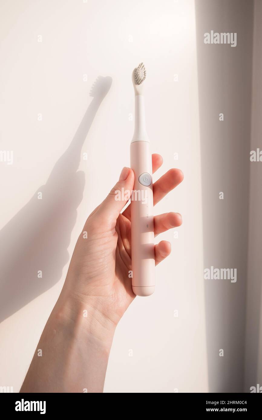 New modern ultrasonic toothbrush in woman hand. Jaw model and dental ...
