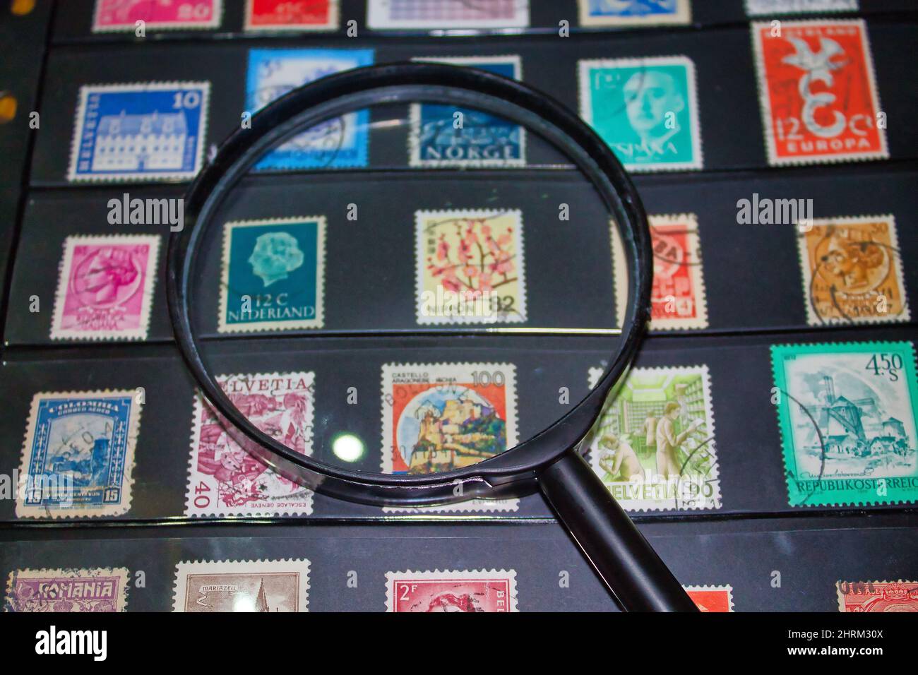 Magnifying glass on a world stamp collection Stock Photo - Alamy