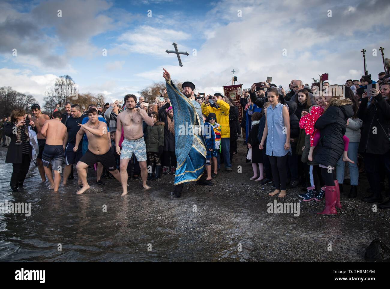 Father Constantinos Economos, centre, throws a cross into the frigid ...