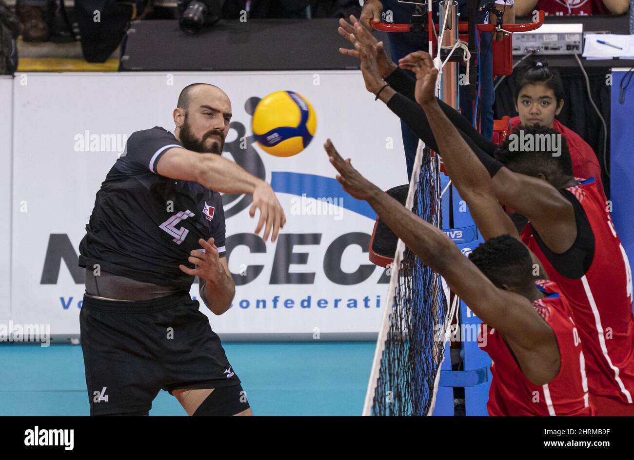 Nicholas Hoag of Canada (left) tries to spike past the block of Livan ...