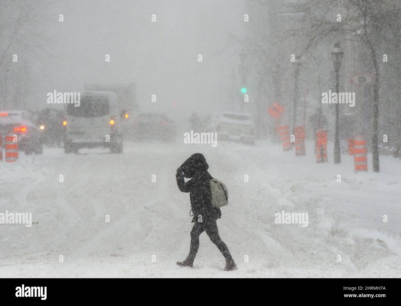 A pedestrian walks through the blowing snow during a snowstorm, Friday ...