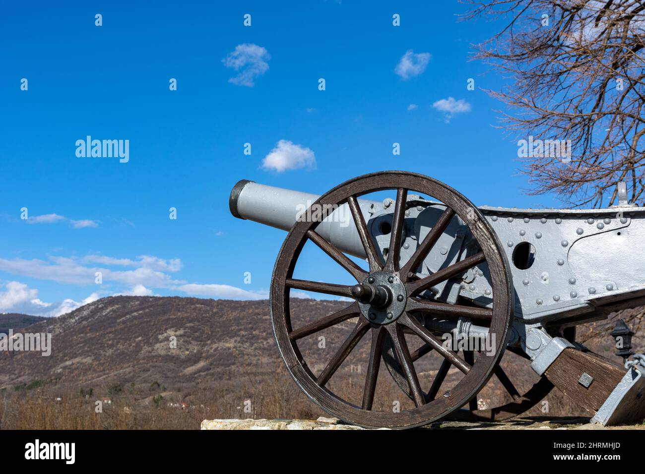 A very old howitzer cannon with wooden wheels aimed high in the sky ...