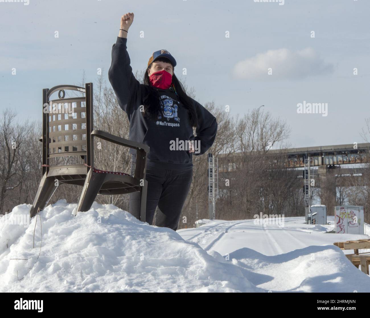 A member of the Mohawk community stands on top of a snow blockade of ...