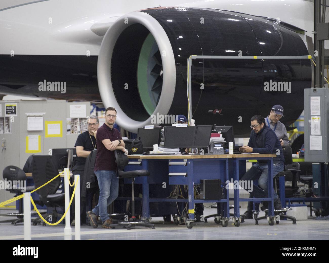 Airbus employees work next to the engine of Airbus A220 at the assembly ...