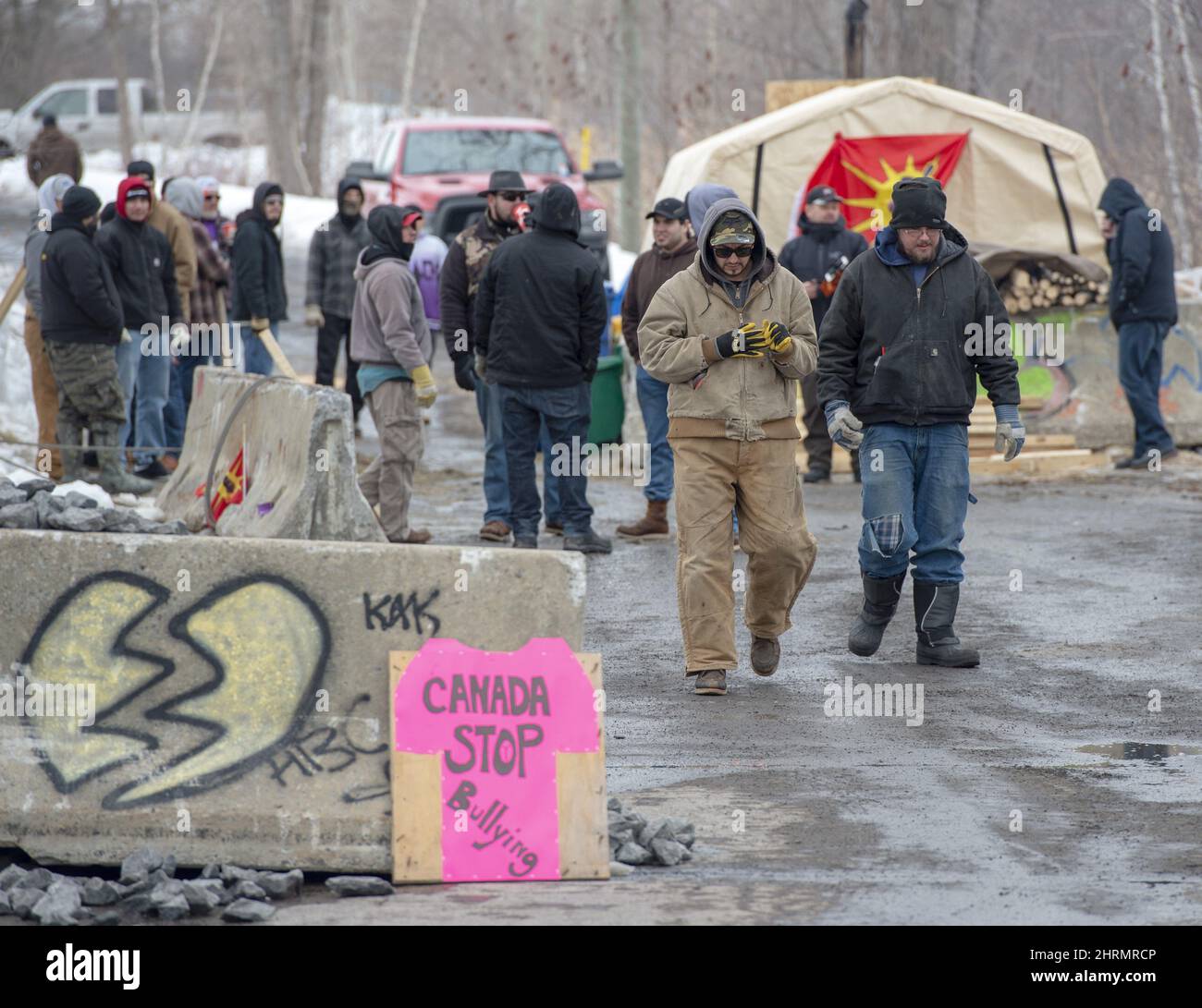 Members of the Mohawk community stand near the entrance to the blockade ...