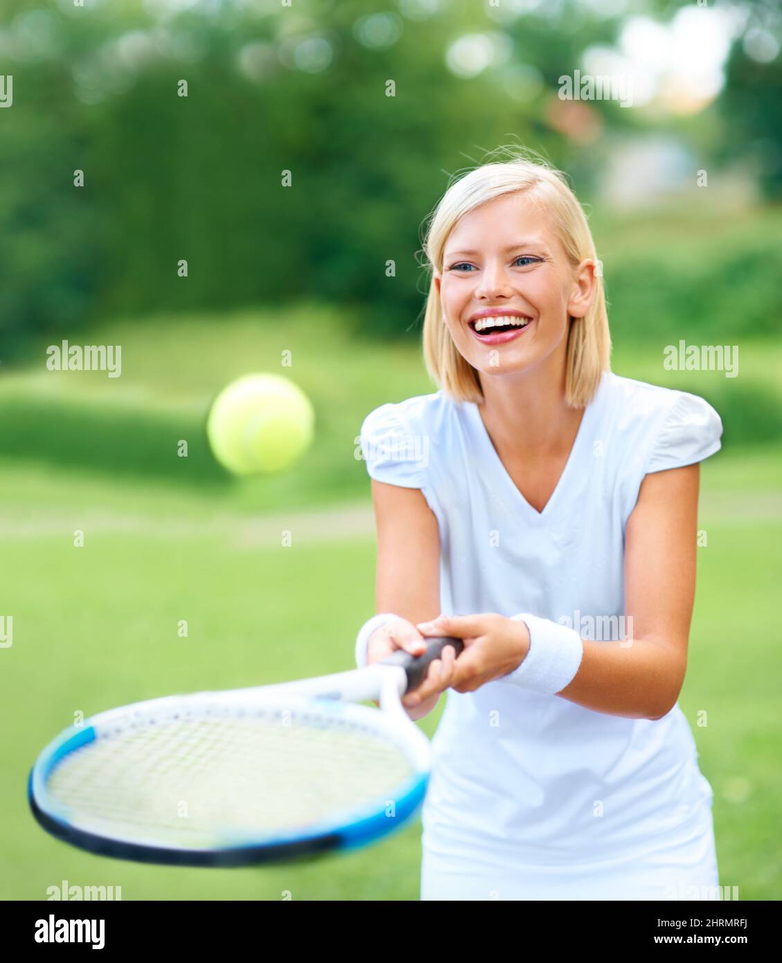 Just for fun. A young female tennis player bouncing the ball on her ...