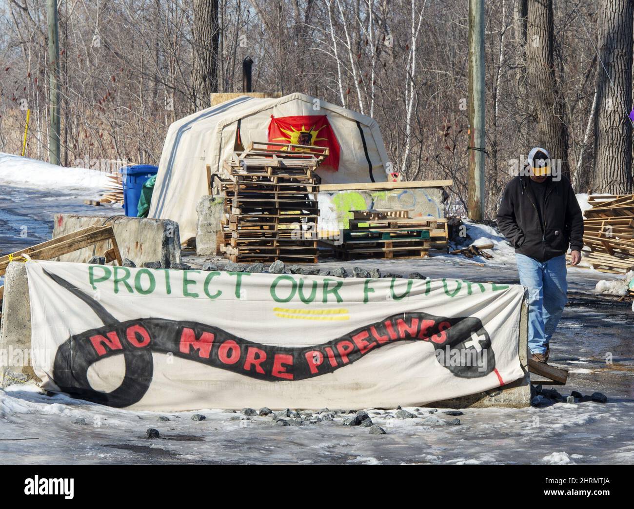 A member of the Mohawk community stands near the blockade of the ...