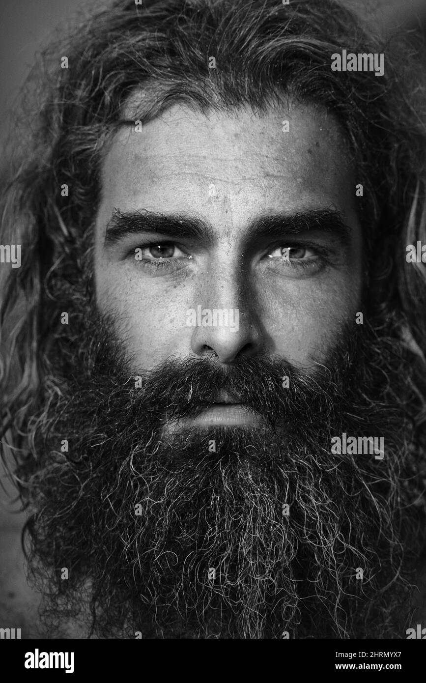 Grayscale portrait of a Caucasian male with a beard looking forward ...