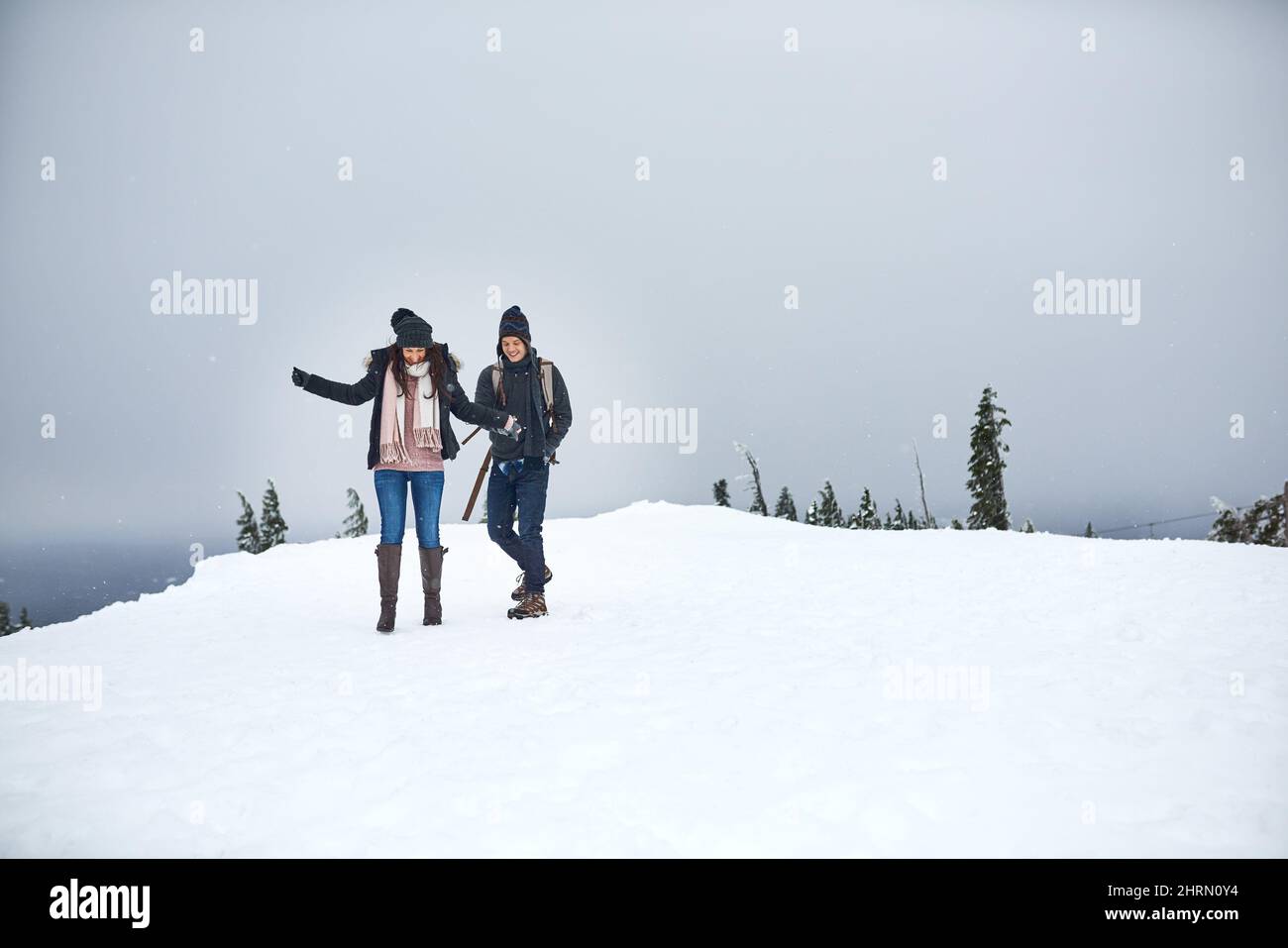 We love being out in the snow. Shot of a happy young couple enjoying ...