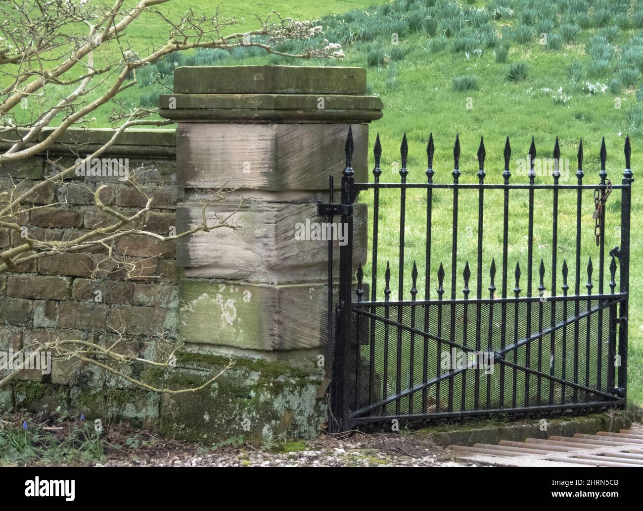 Wrought iron balck gateway with stone wall Stock Photo - Alamy