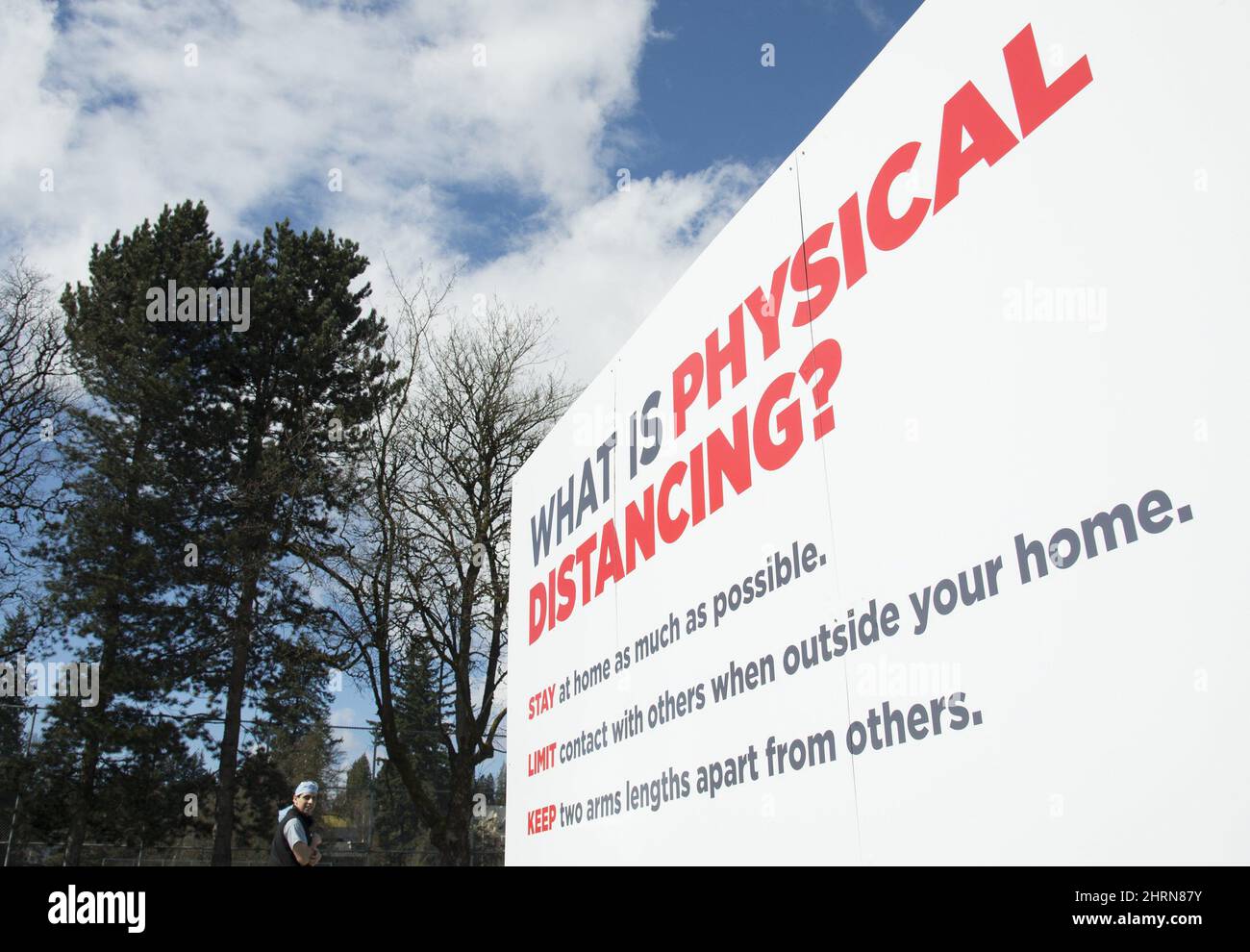 A man walks past a physical distancing sign at the Royal Columbian ...