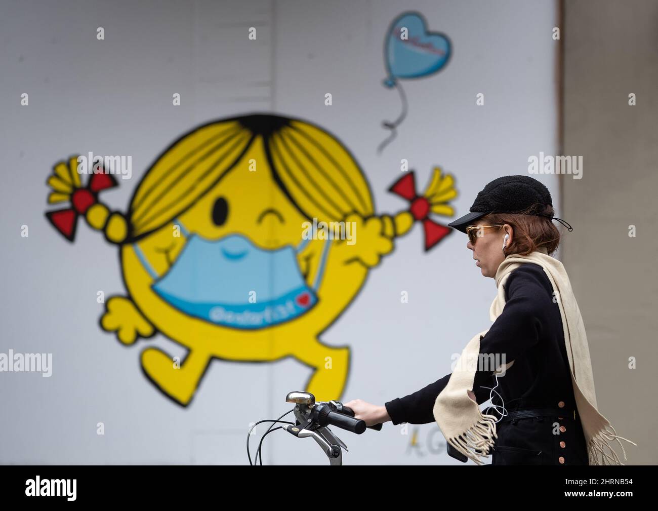 A woman rides a bike past artwork of author and illustrator Roger ...