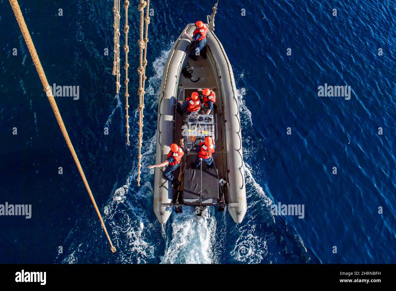 Pacific Ocean. 13th Feb, 2022. Sailors grab lines while raising a Rigid ...