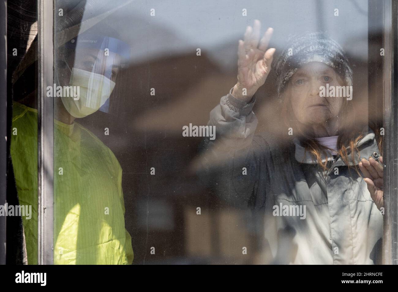 A resident named Joyce waves as she stands with a staff member to watch ...