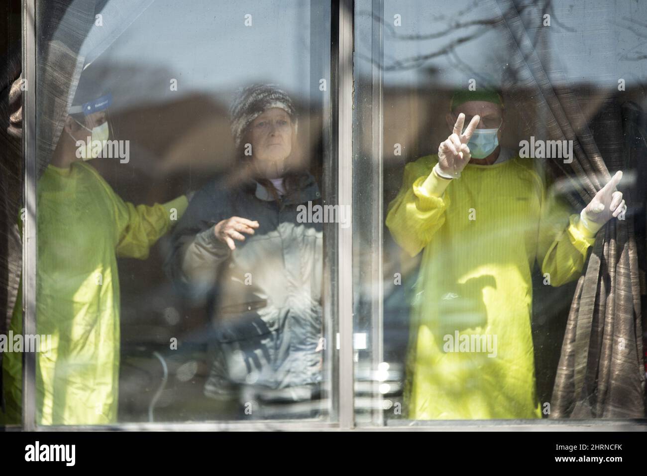 A resident named Joyce stands with staff members to watch well wishers ...