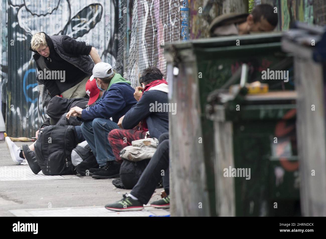 People are seen in close proximity to one another in a back alley in ...