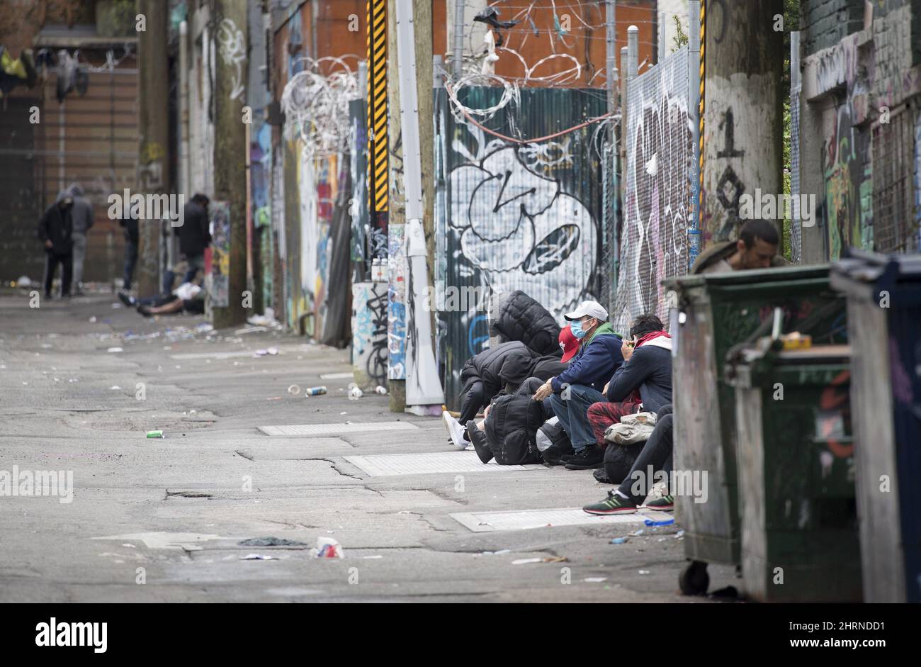 People are seen in close proximity to one another in a back alley in ...