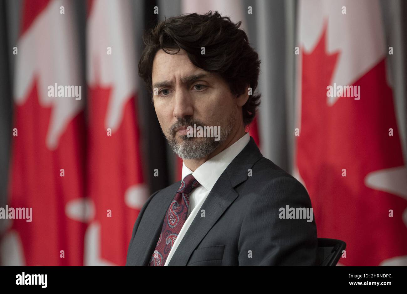 Prime Minister Justin Trudeau listens as a speaker lists Canadian mass ...
