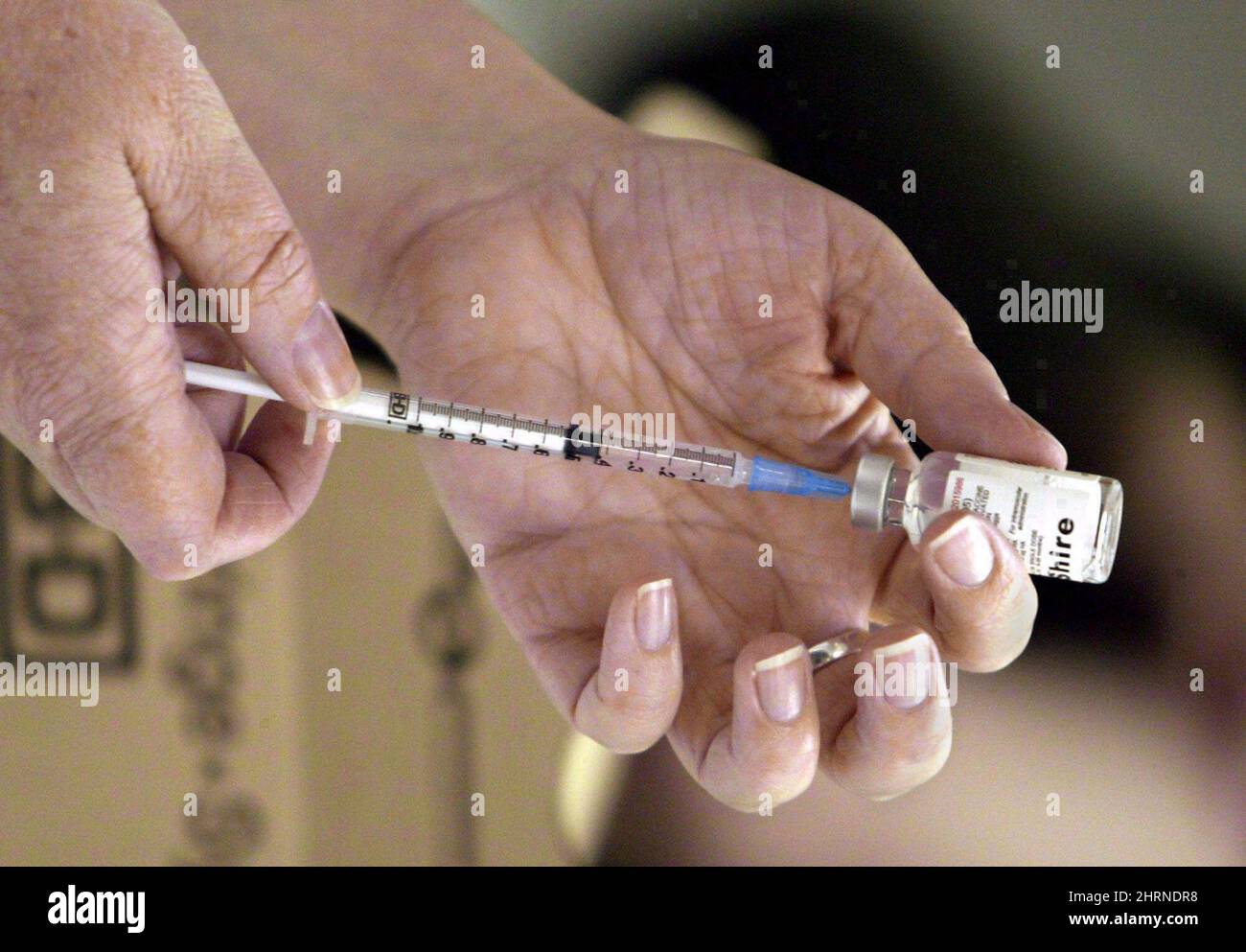 A nurse loads a syringe with vaccine for injection in Victoria ...