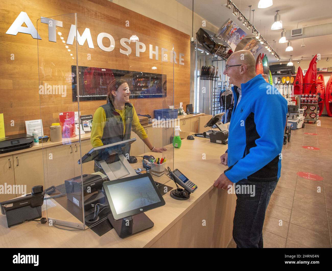 Laurence Rochon stands behind protective plexiglass as she speaks with ...