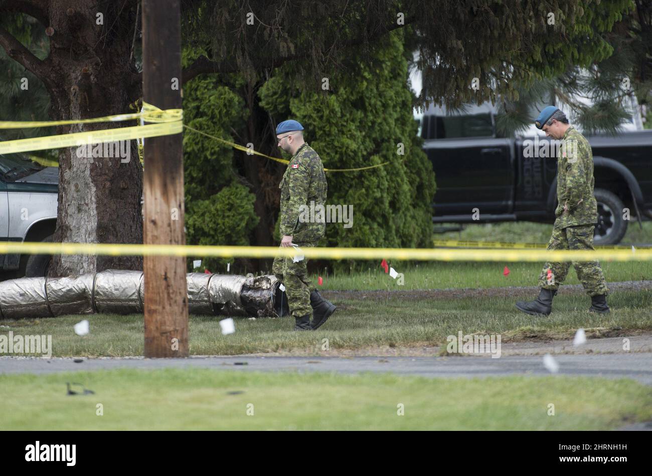 Members of the Canadian Forces walk by the crash site of a Canadian ...