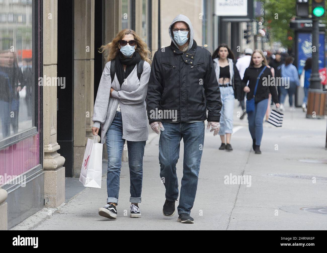 People with face masks and without face masks walk along Sainte ...