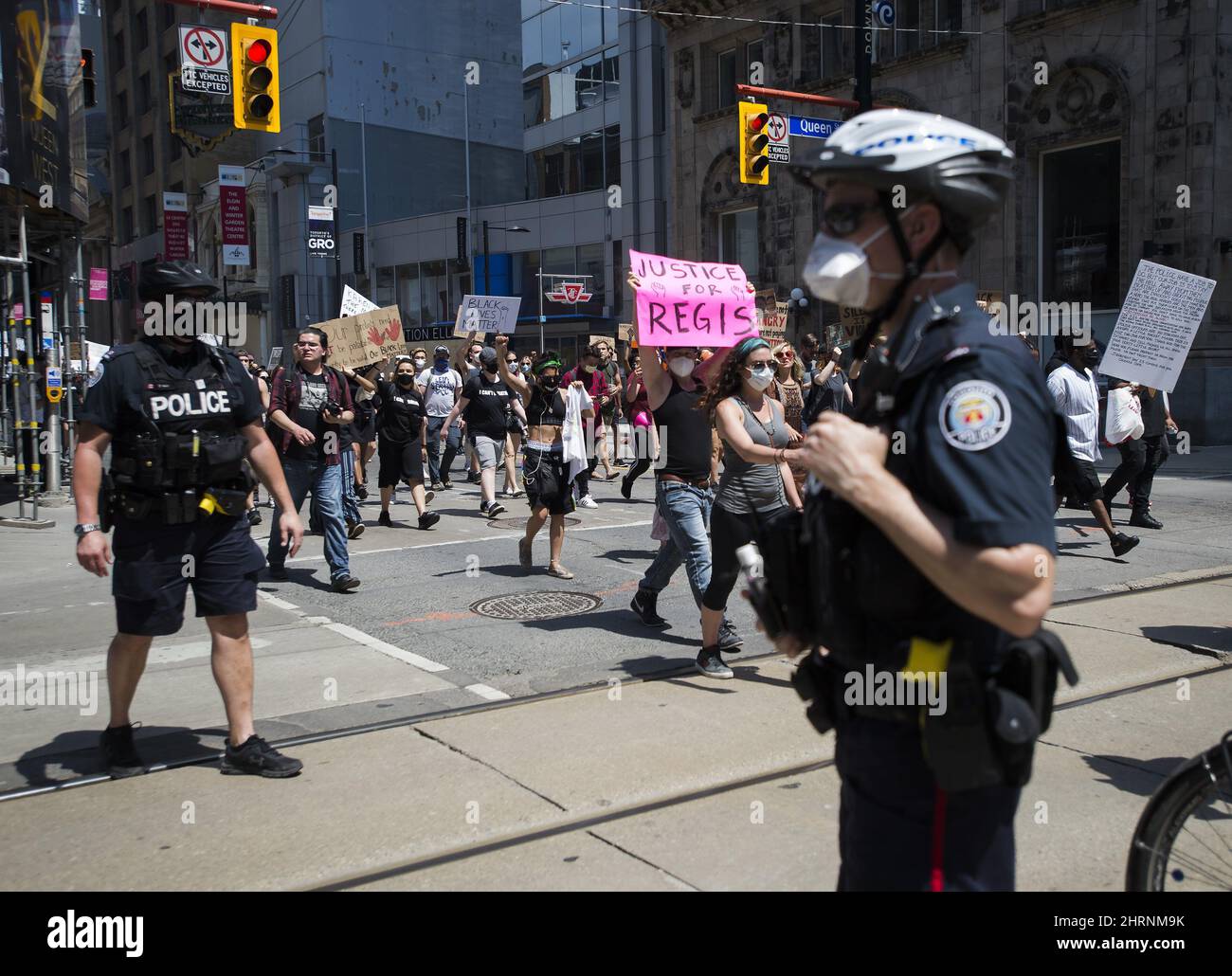 Police officers look on as thousands of people protest at an anti ...