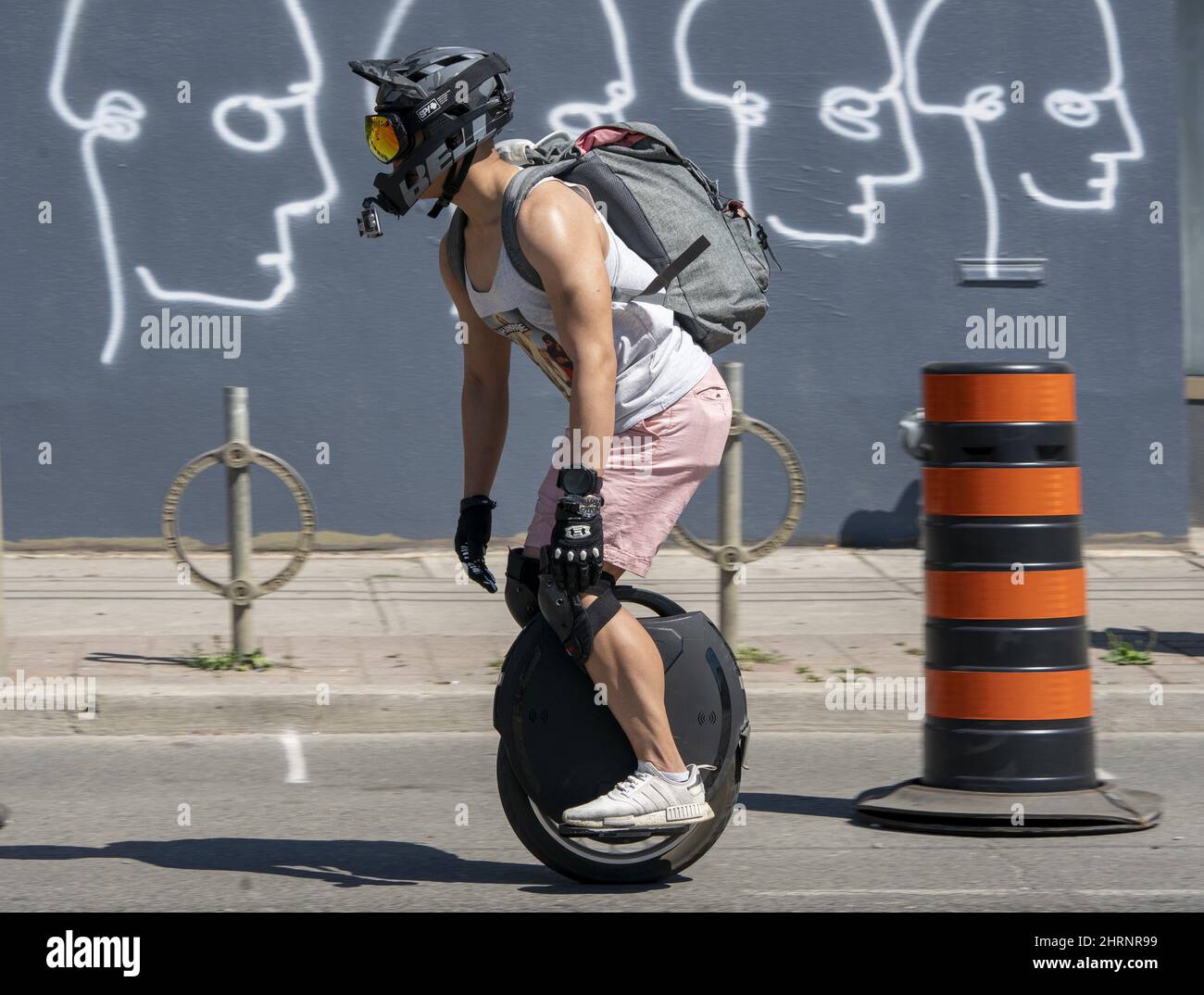 A man on a single wheel scooter races down a city street in Toronto on ...