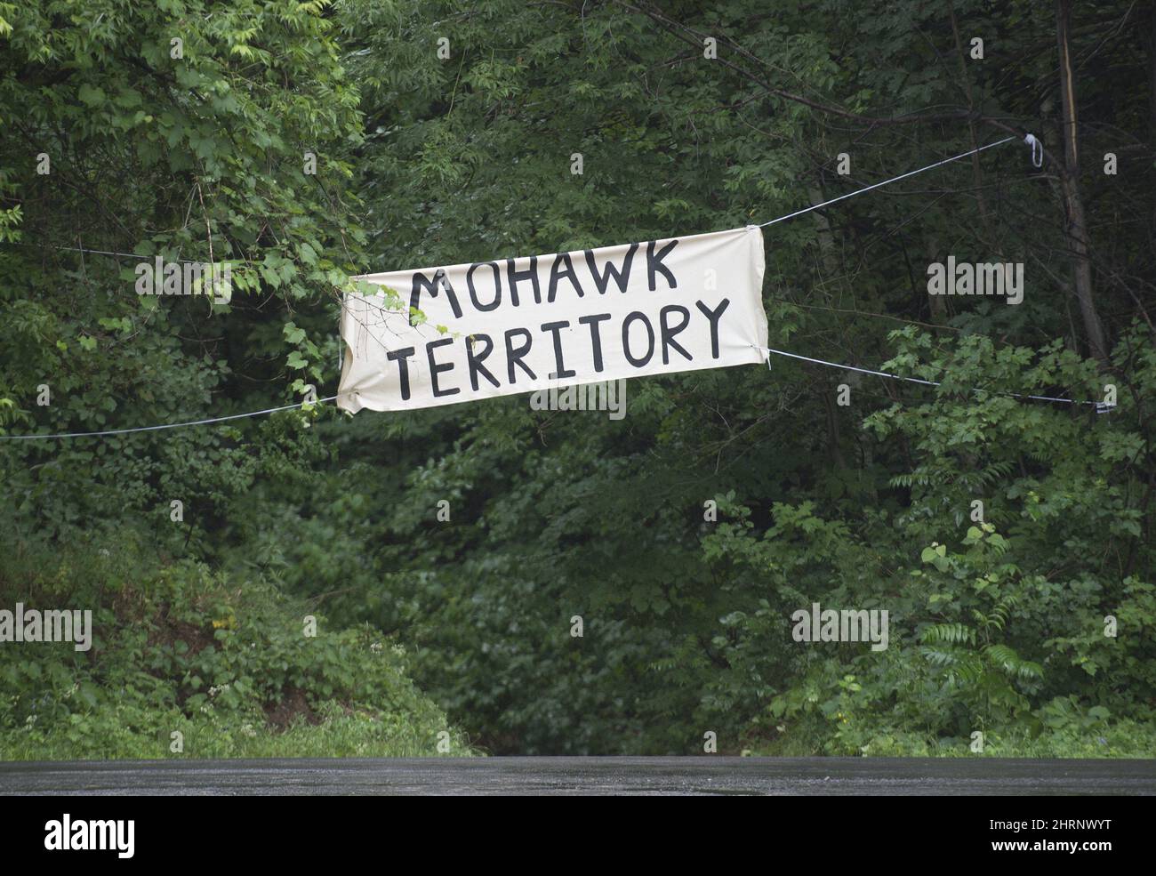 A sign hangs from trees on the thirty year anniversary of the Oka ...