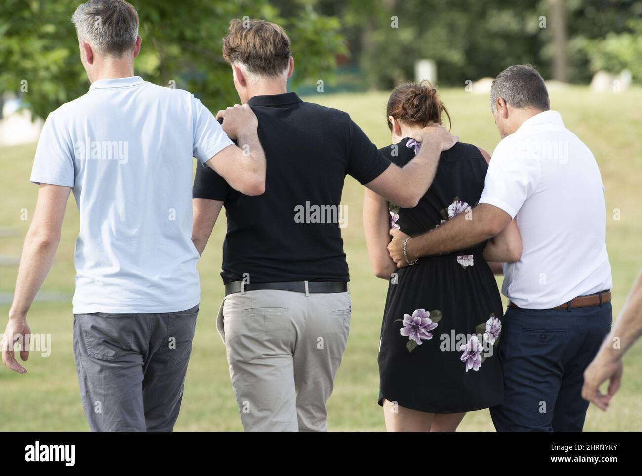 Amelie Lemieux, second right, is comforted by family members as she ...