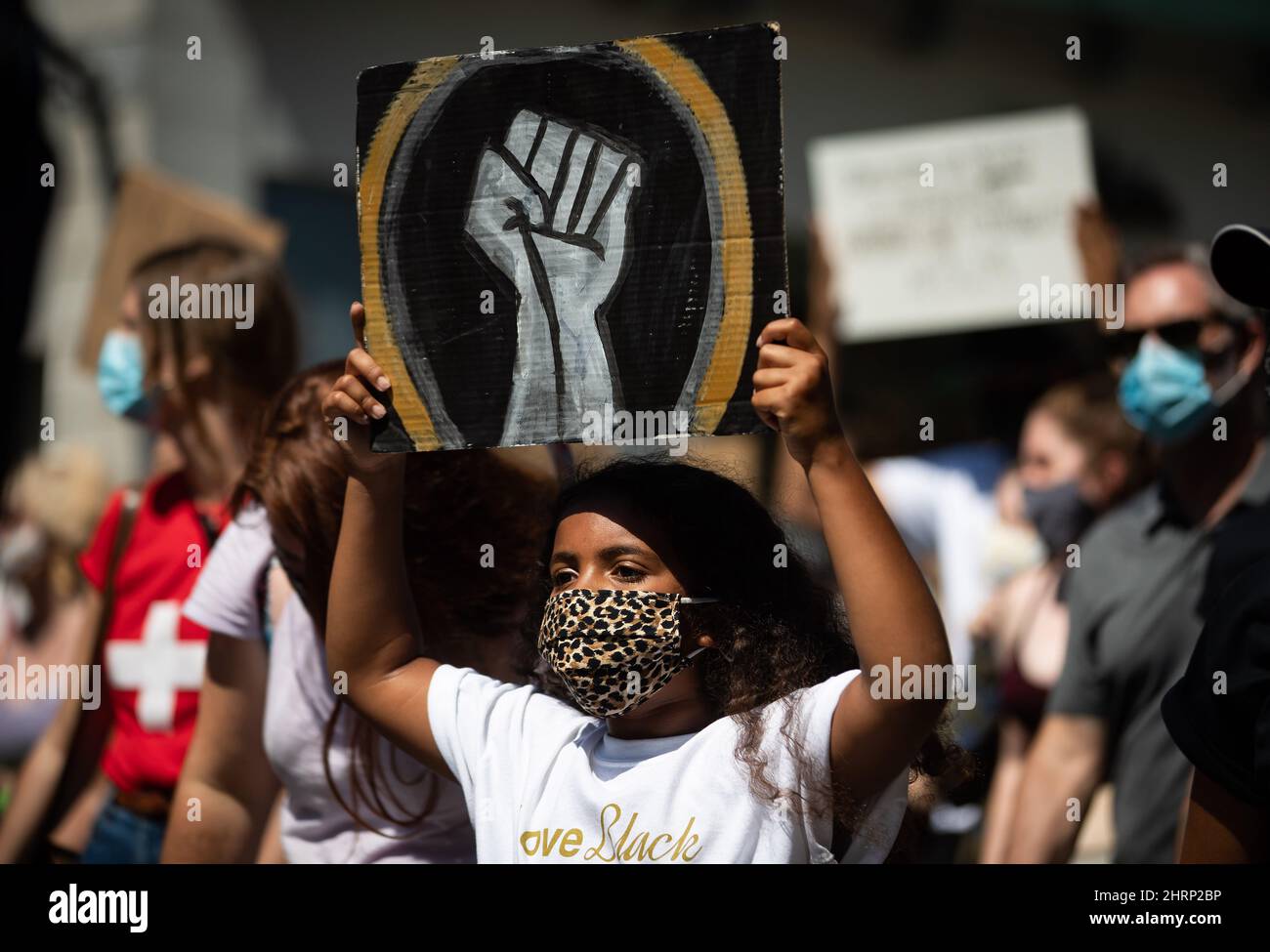 A young girl holds up a sign as she marches with hundreds of others ...
