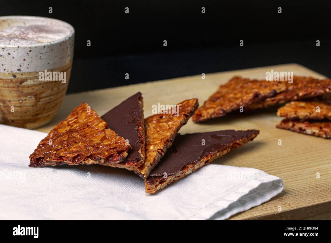 Wooden board with thin triangular chocolate nut biscuits Stock Photo ...