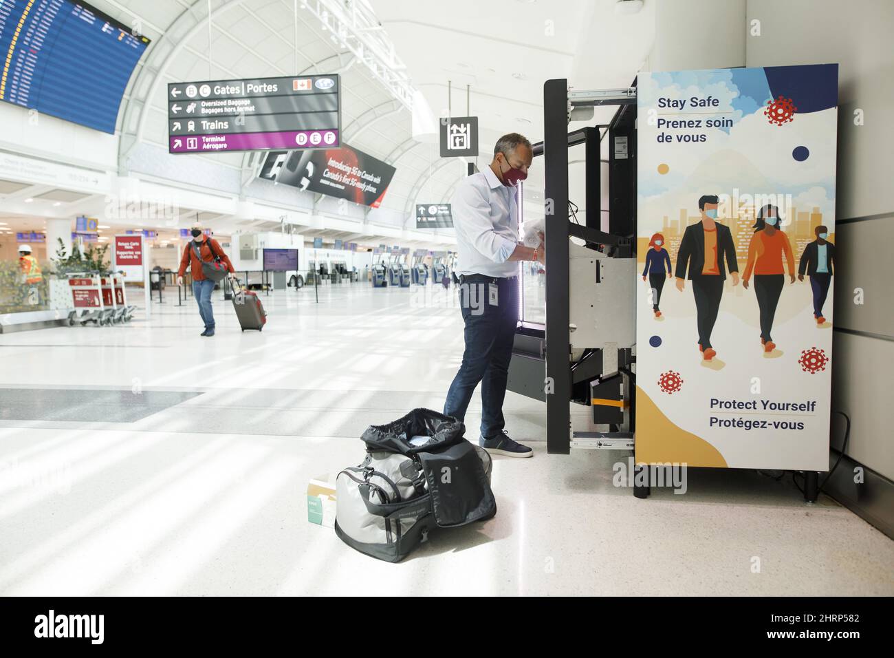Gilad Levy refills a PPE vending machine at Pearson International ...