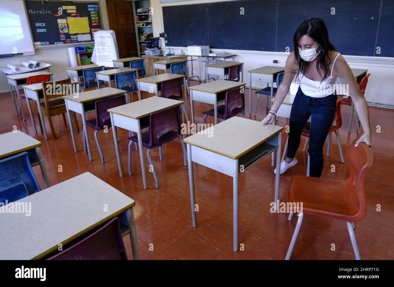 Grade one teacher Heidi Dimou arranges the desks in line with physical ...
