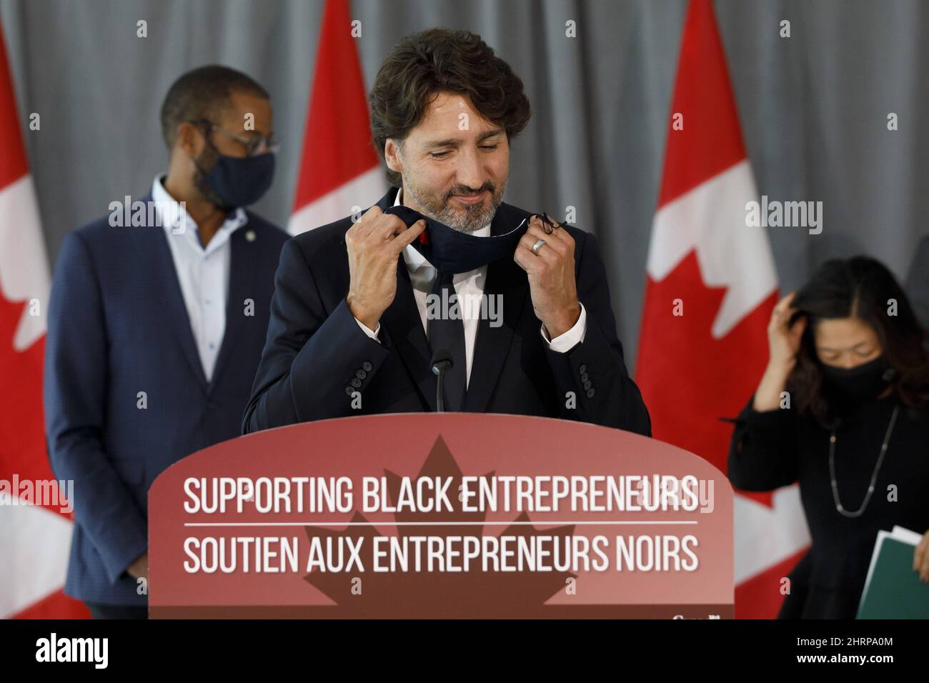 Prime Minister Justin Trudeau removes his mask before speaking during a ...