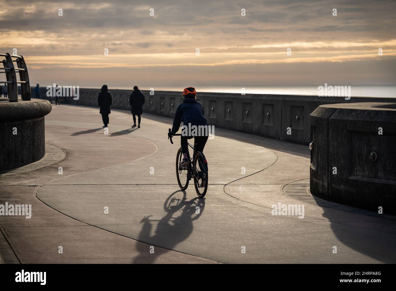People walking and biking in the morning on the seafront path in ...