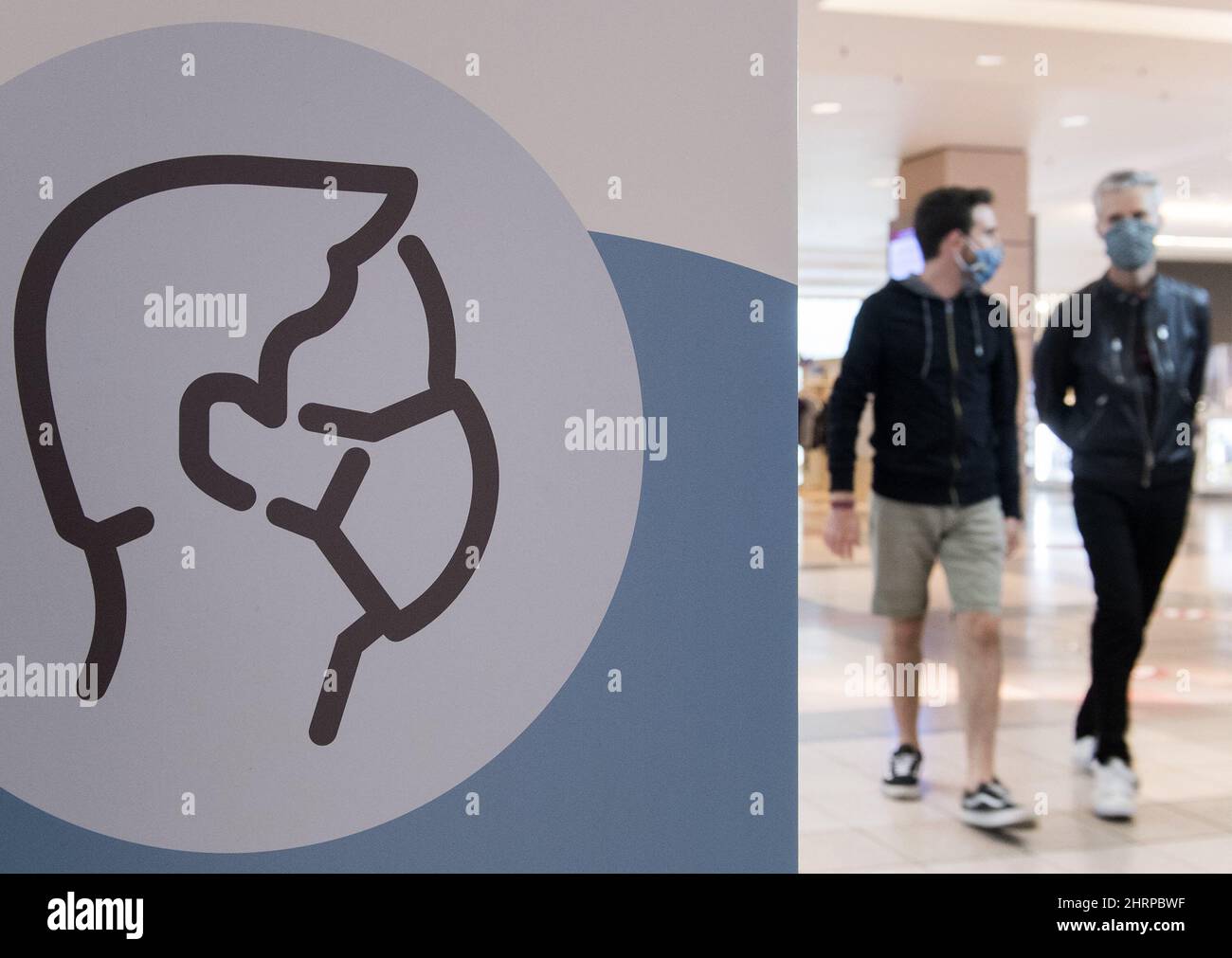 People wear face masks as they walk through a shopping mall in Montreal ...