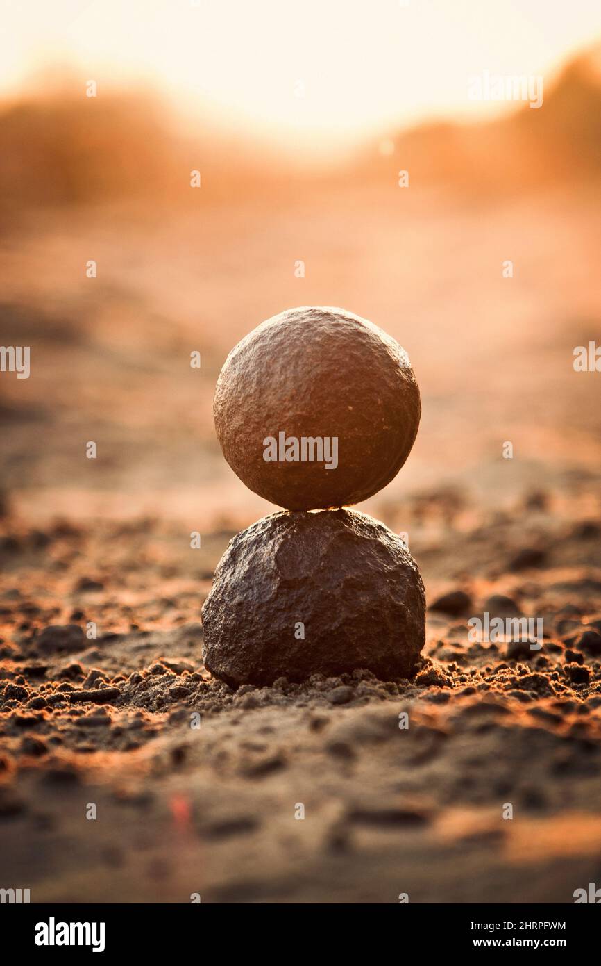 Vertical shot of rock balls under the half Moon shaped woods with a ...