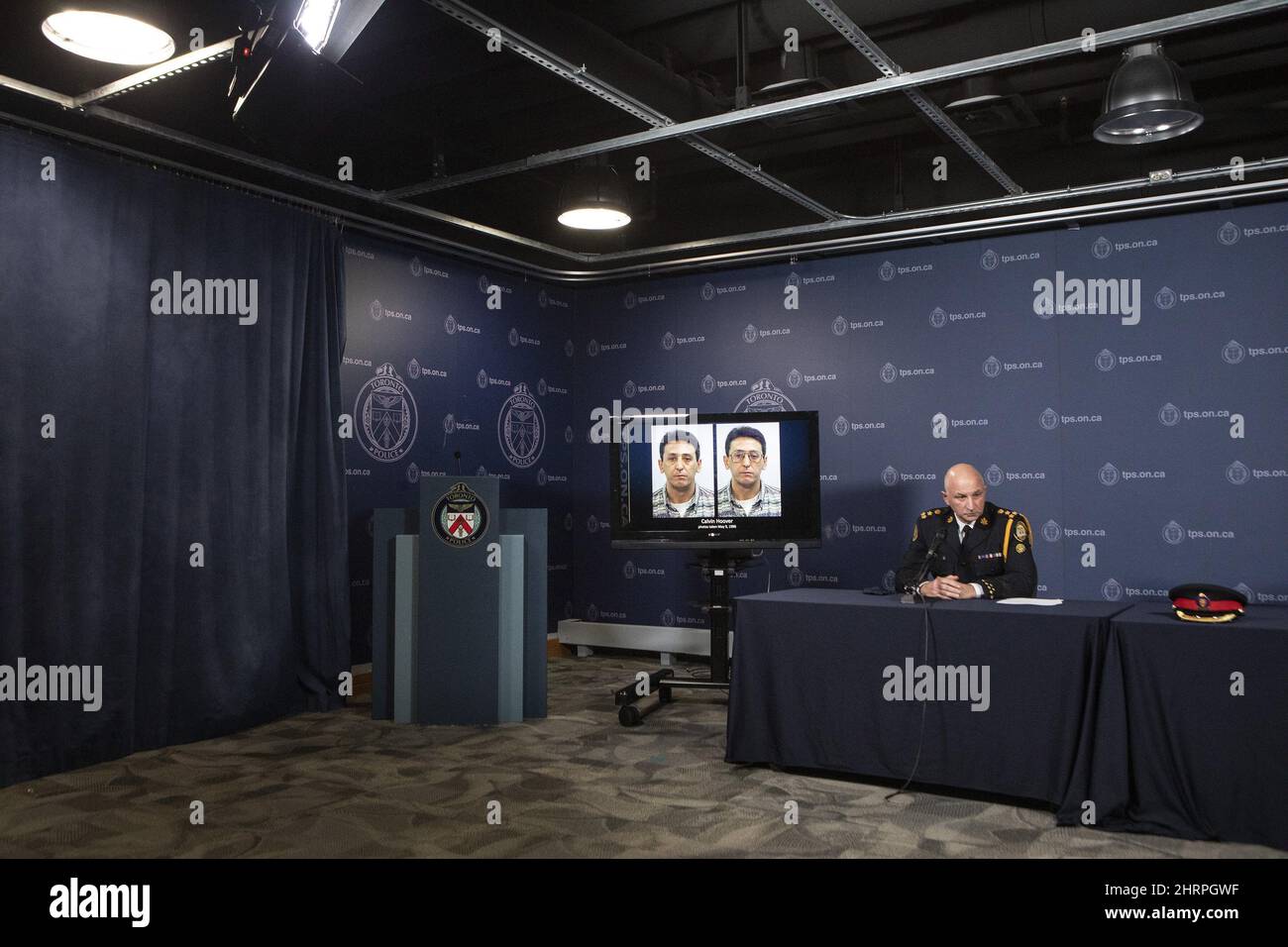 Toronto Police Chief James Ramer sits next to a screen displaying ...