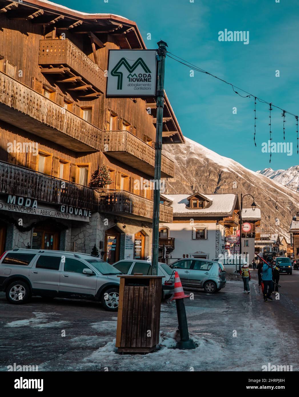 Vertical street view of traditional alpine houses with shops and people ...